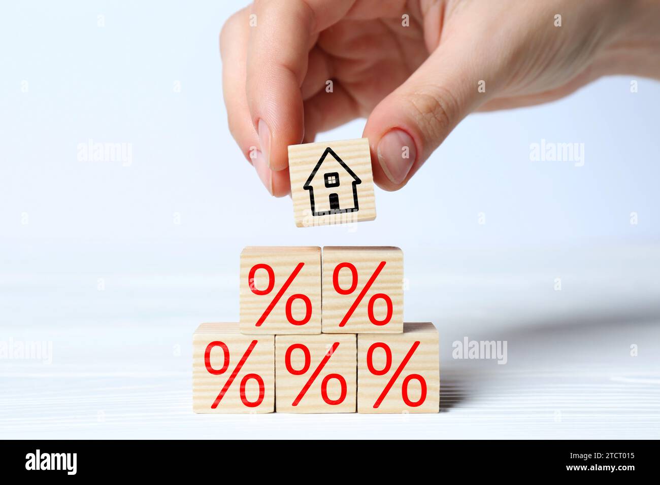 Mortgage rate. Woman building pyramid of cubes with house icon and ...