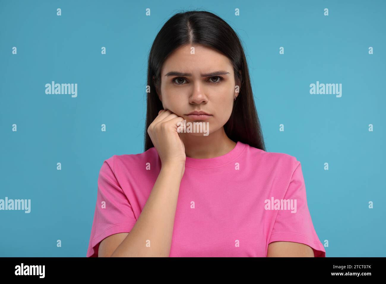 Portrait of resentful woman on light blue background Stock Photo - Alamy