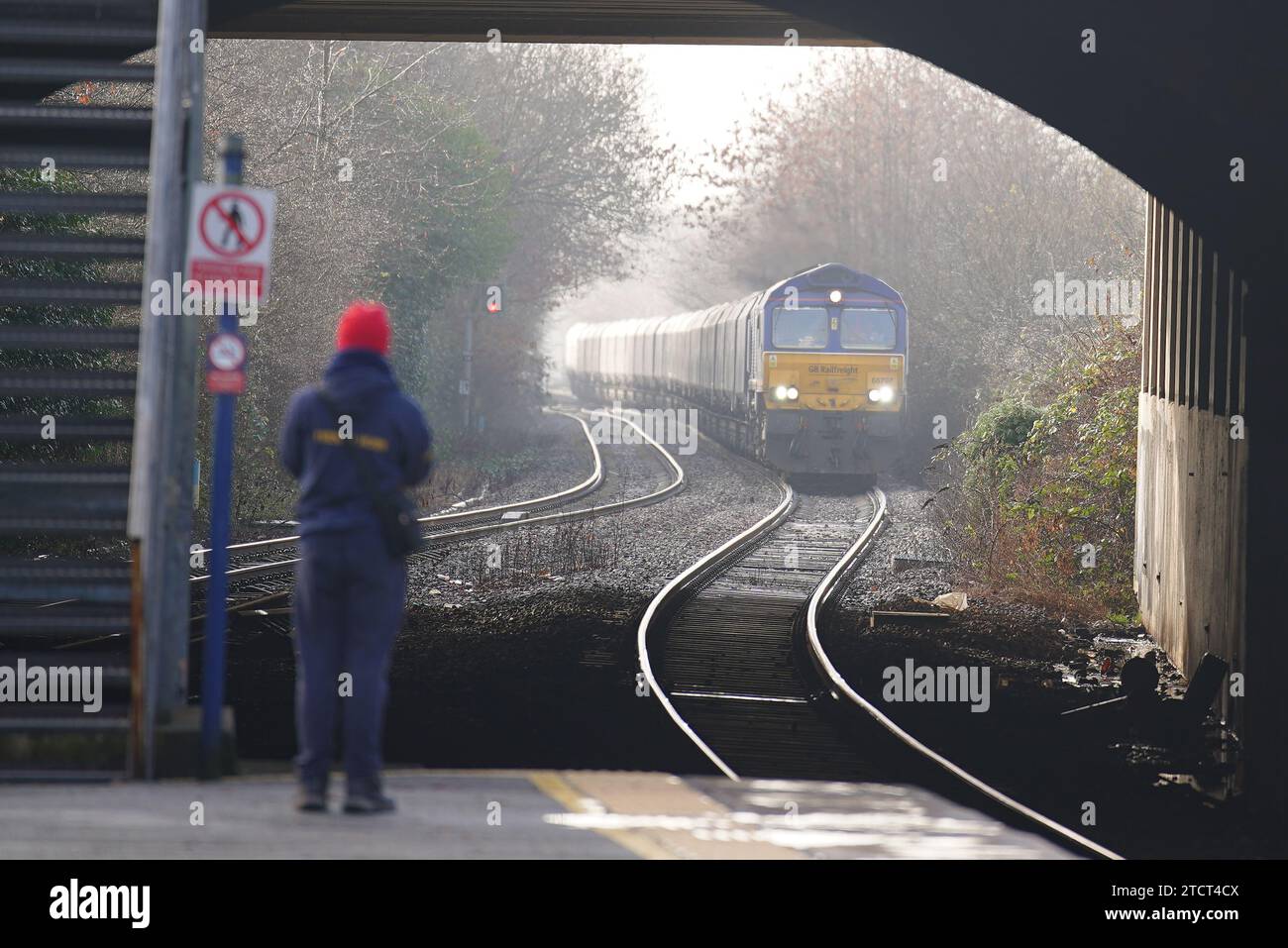 A passenger waits for a train at Denton railway station in Greater ...