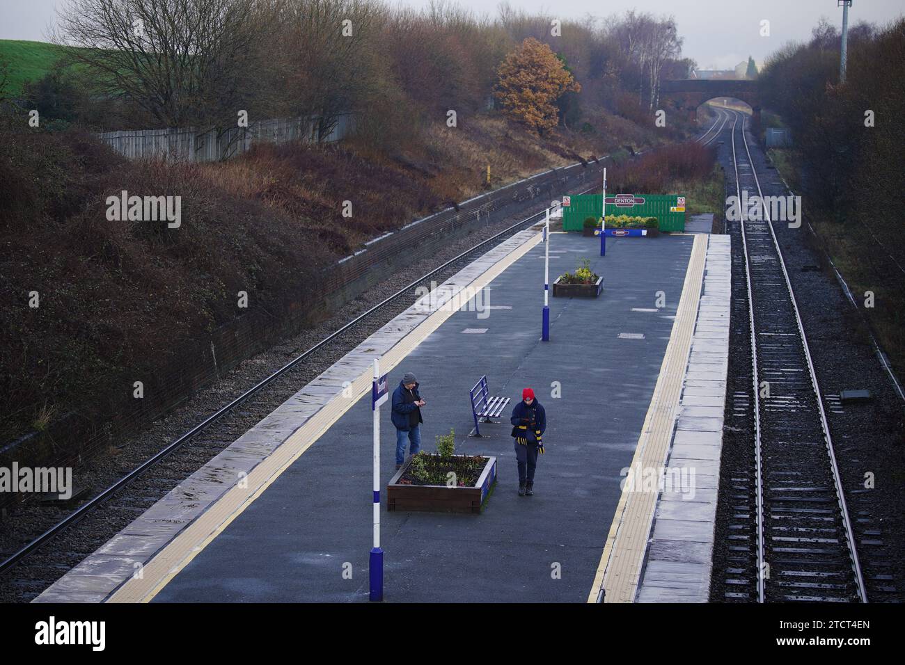 Passengers wait for a train at Denton railway station in Greater ...