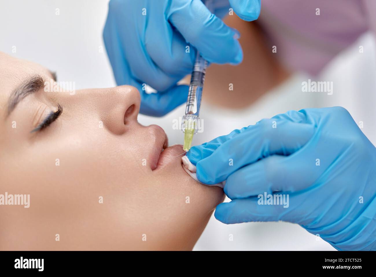 cosmetologist makes injections to enlarge the lips of beautiful woman ...