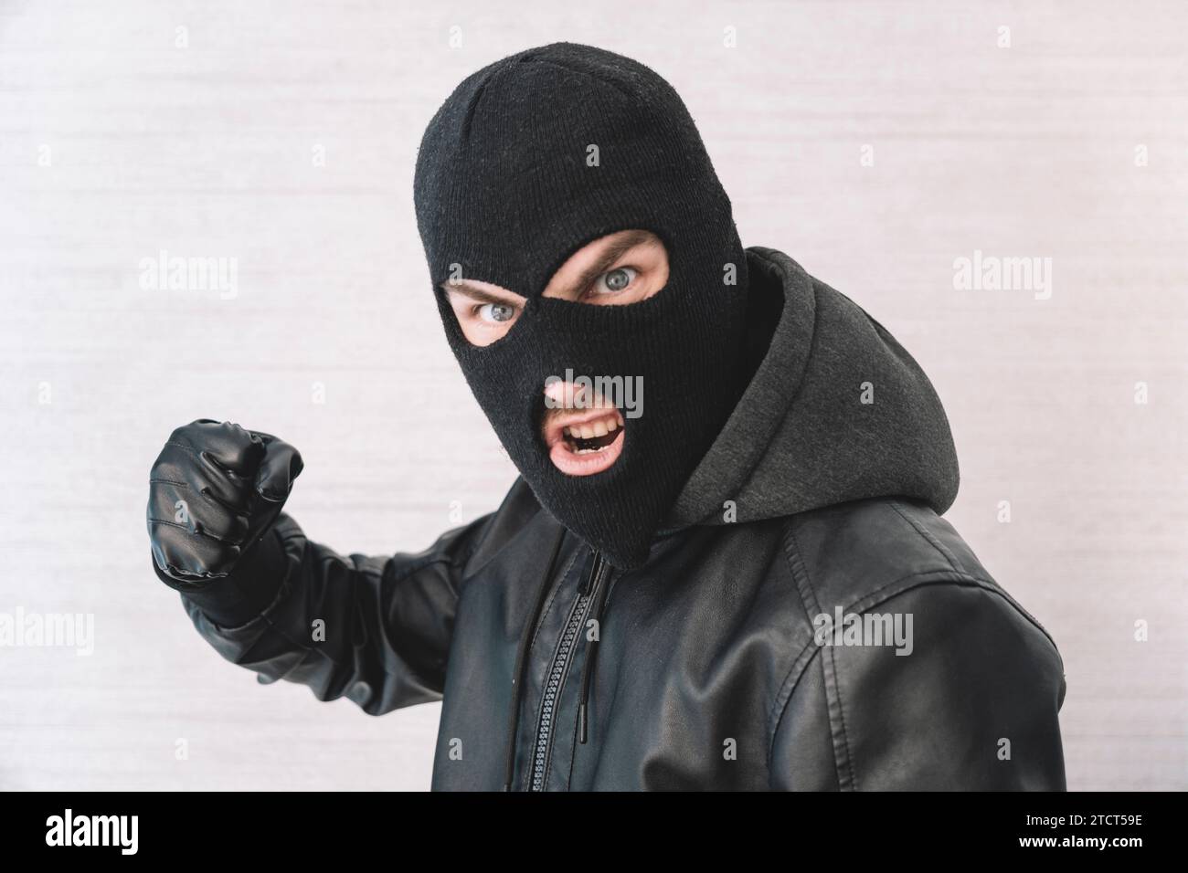 A thief in a black jacket. A man in a black balaclava with an evil ...