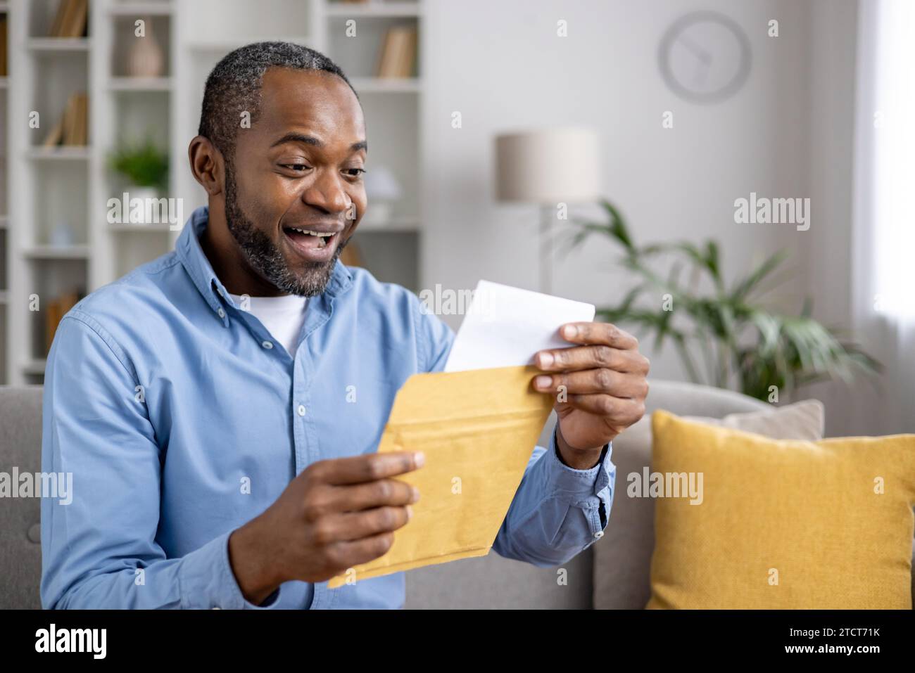 Senior joyful man sitting on sofa at home, satisfied smiling african ...