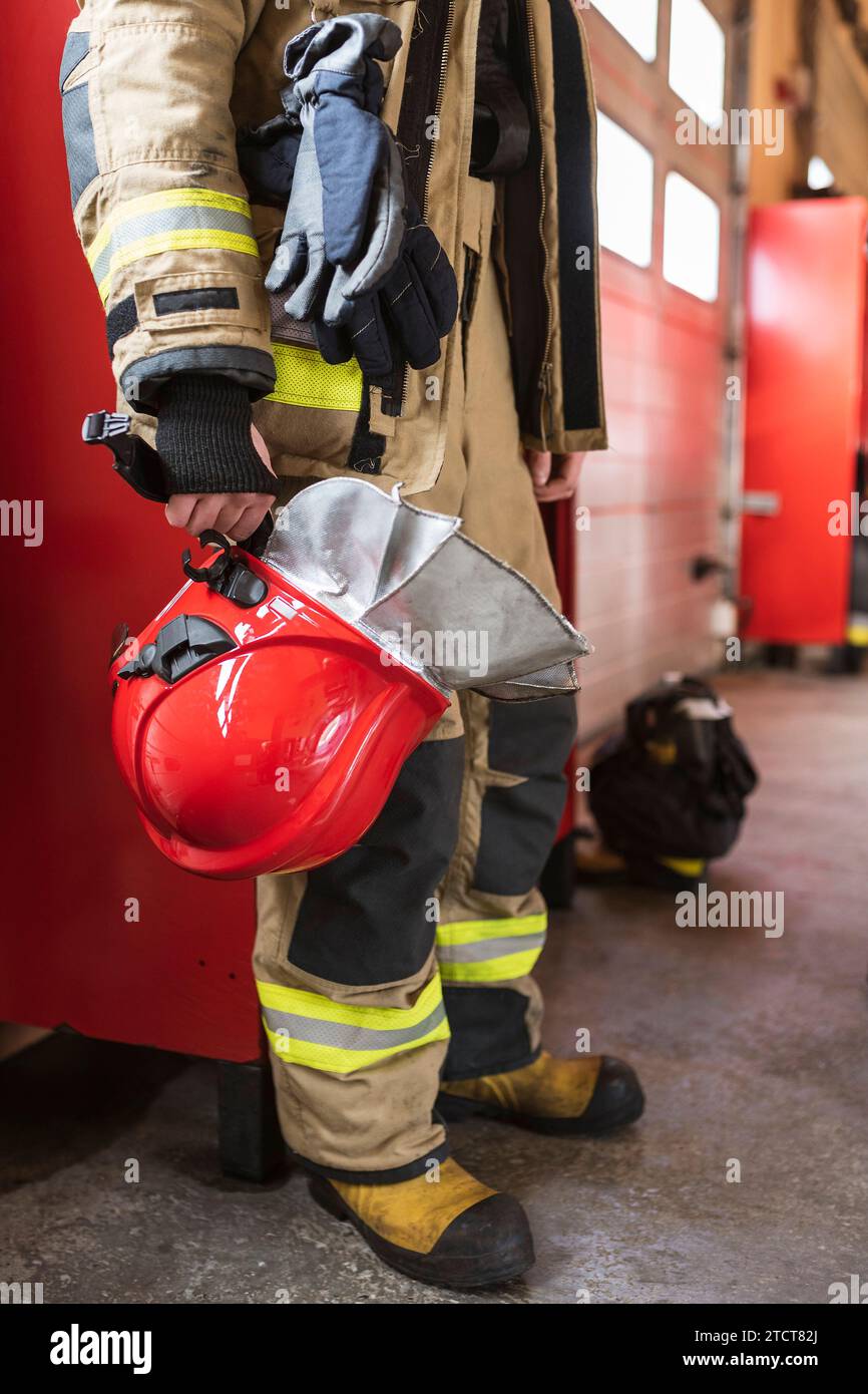 Red helmet in fireman's hand Stock Photo - Alamy