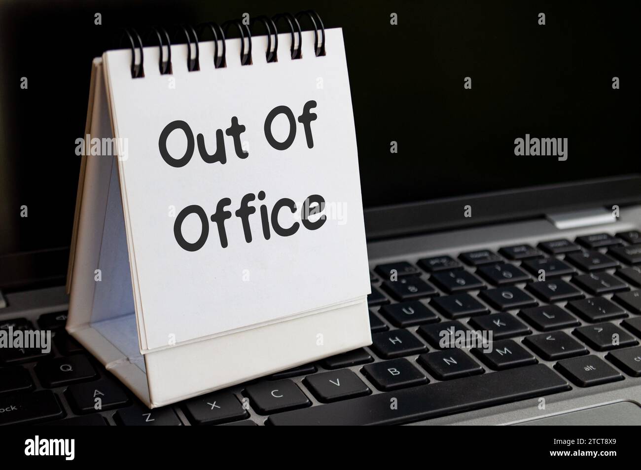 Out of office text on notepad with laptop background. Out of office ...