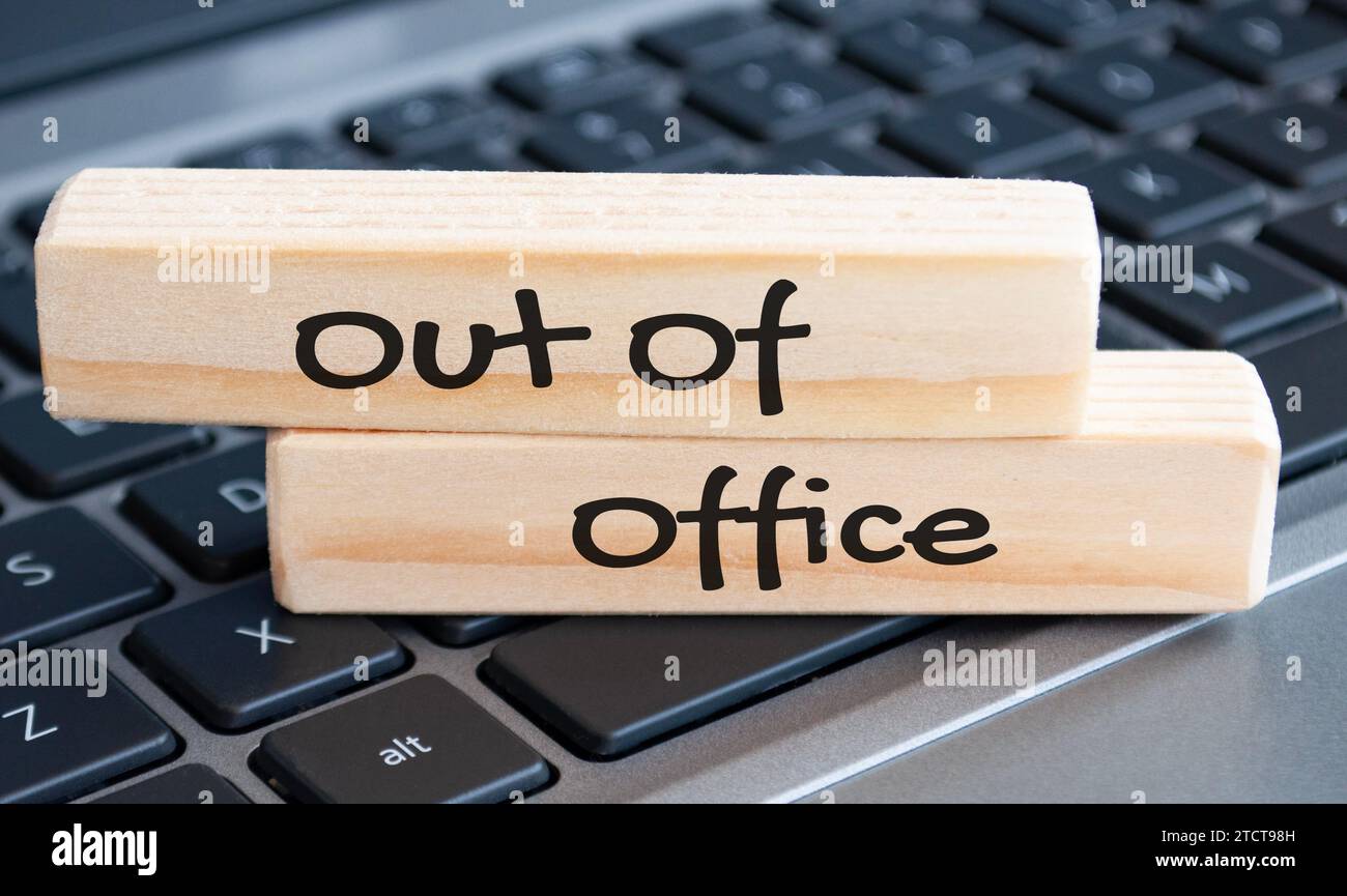 Out of office text on wooden blocks with laptop background. Out of ...