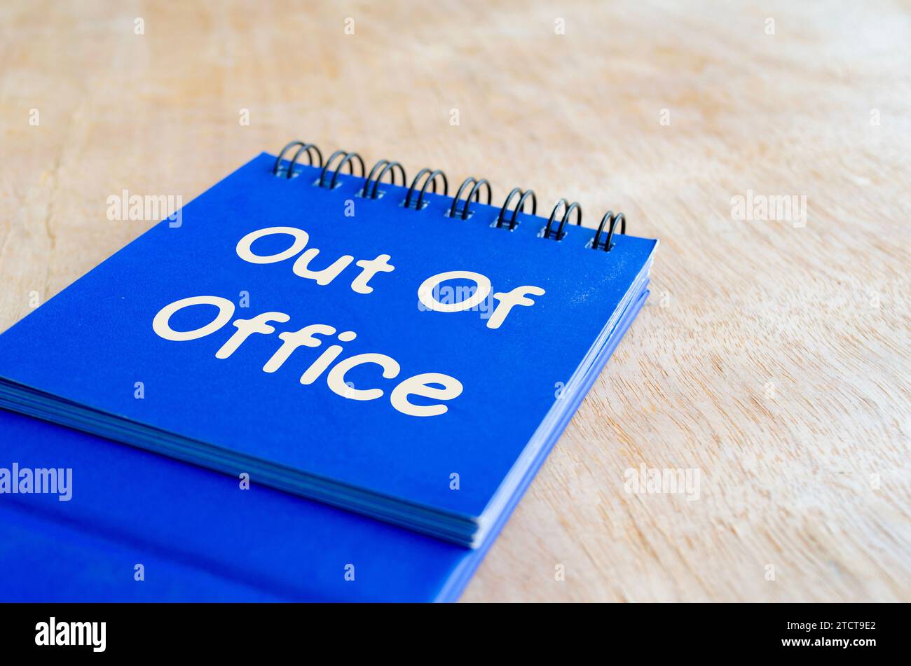 Out of office text on notepad on wooden table background. Out of office ...