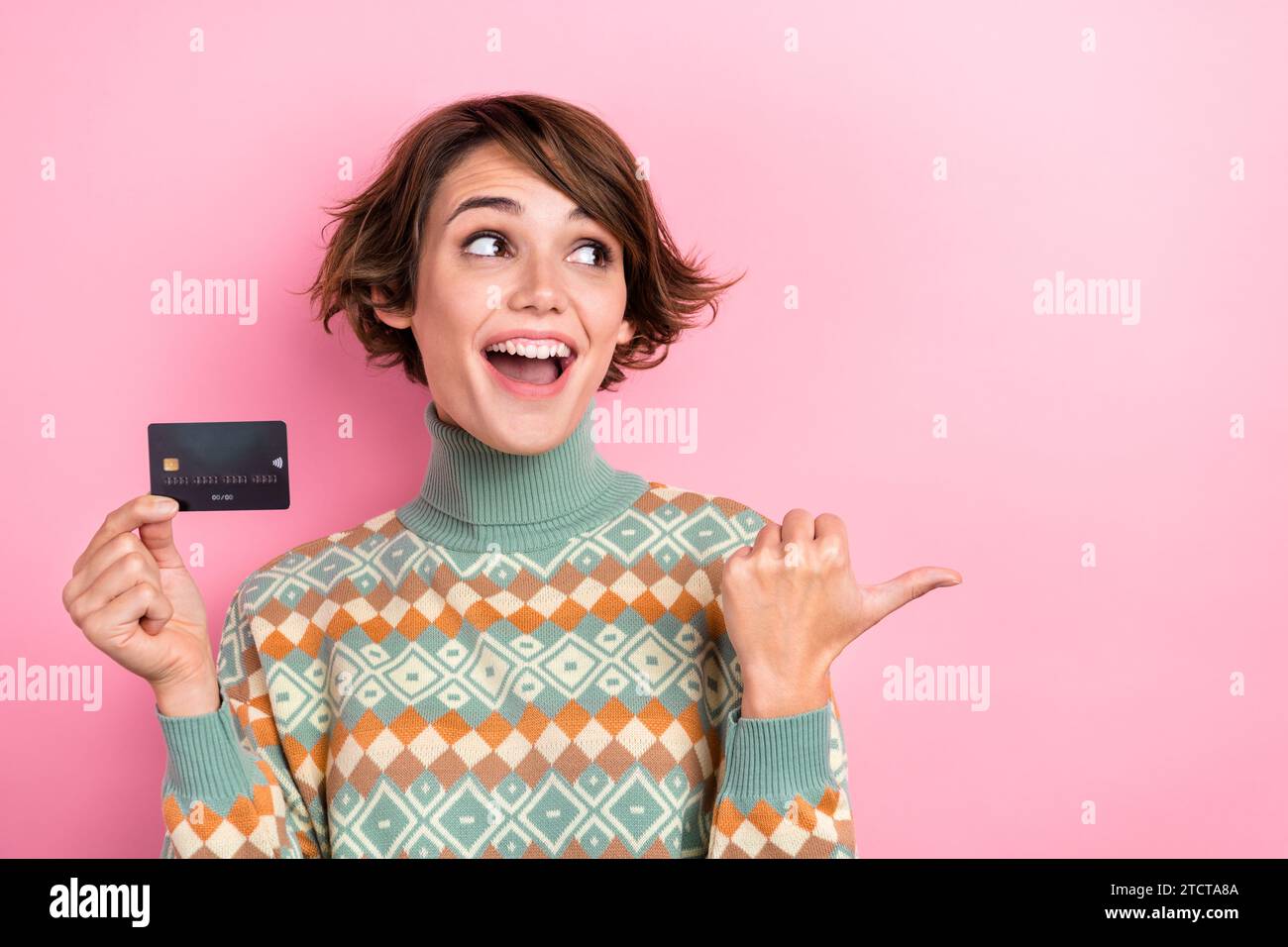 Portrait of astonished attractive lady hold debit card look indicate ...