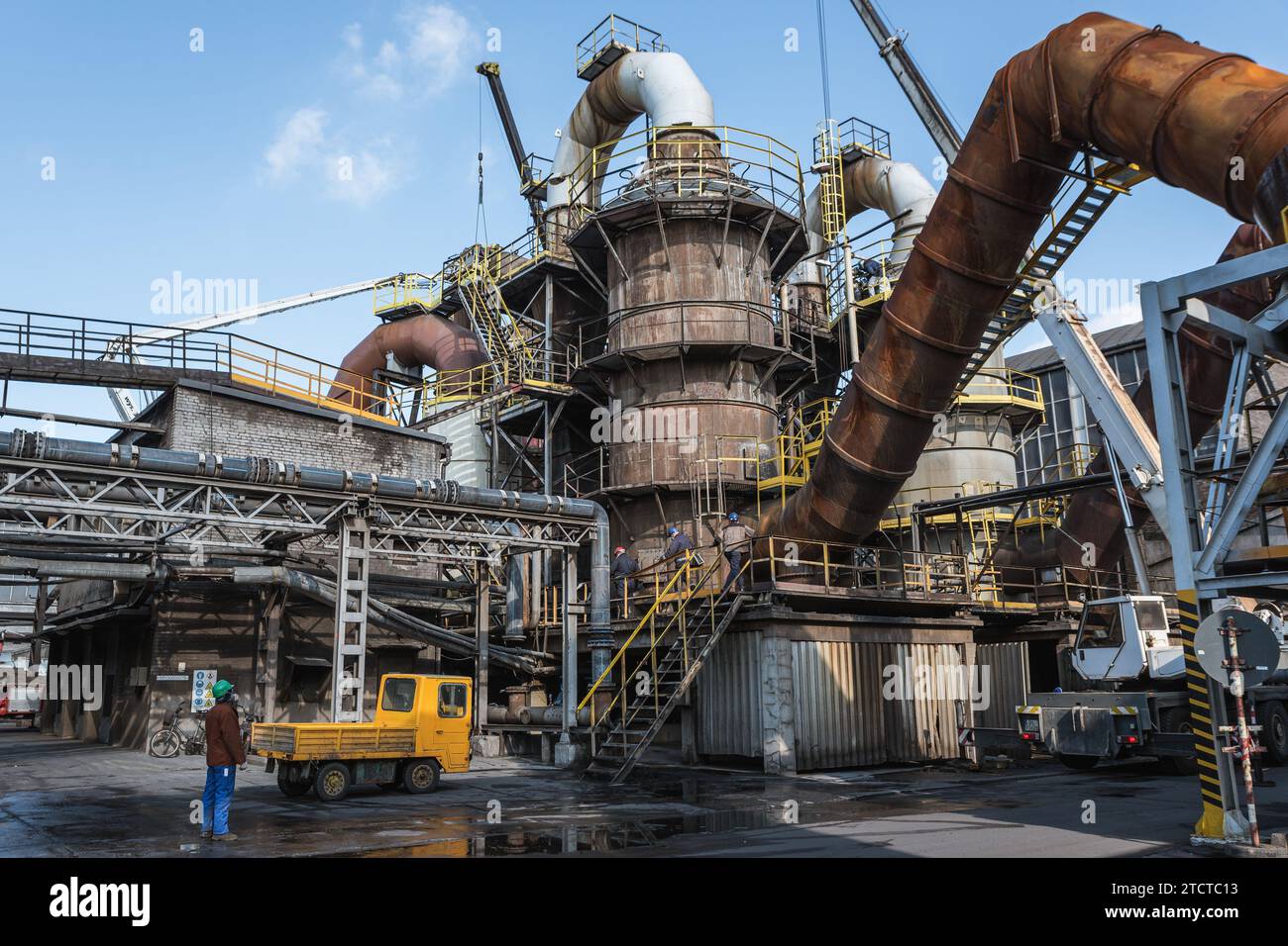 Workers and cranes during assembly of the installation in the smelter ...