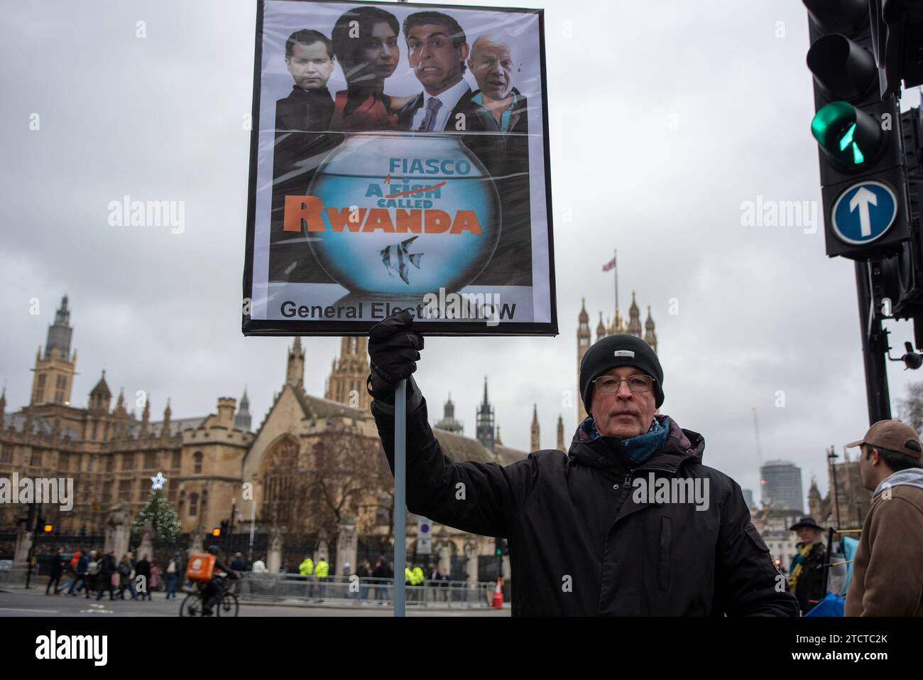 London, UK. 13th Dec, 2023. A protester holds a poster with Rishi Sunak ...
