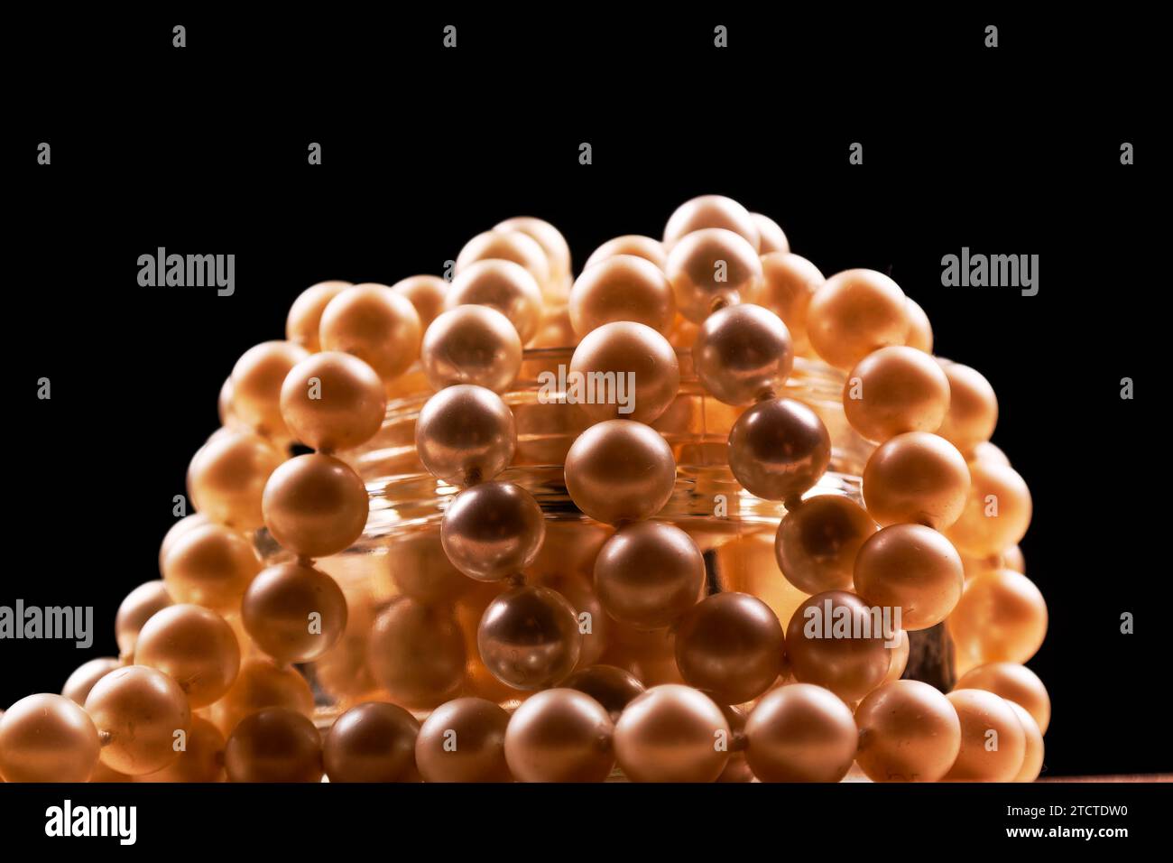 a collection of golden shimmering natural pearls isolated with a black ...