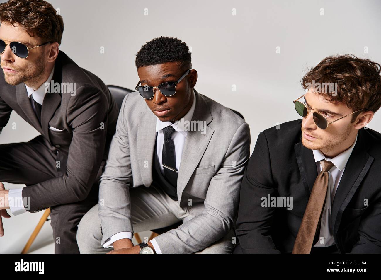 attractive multicultural men with sunglasses in business attires ...