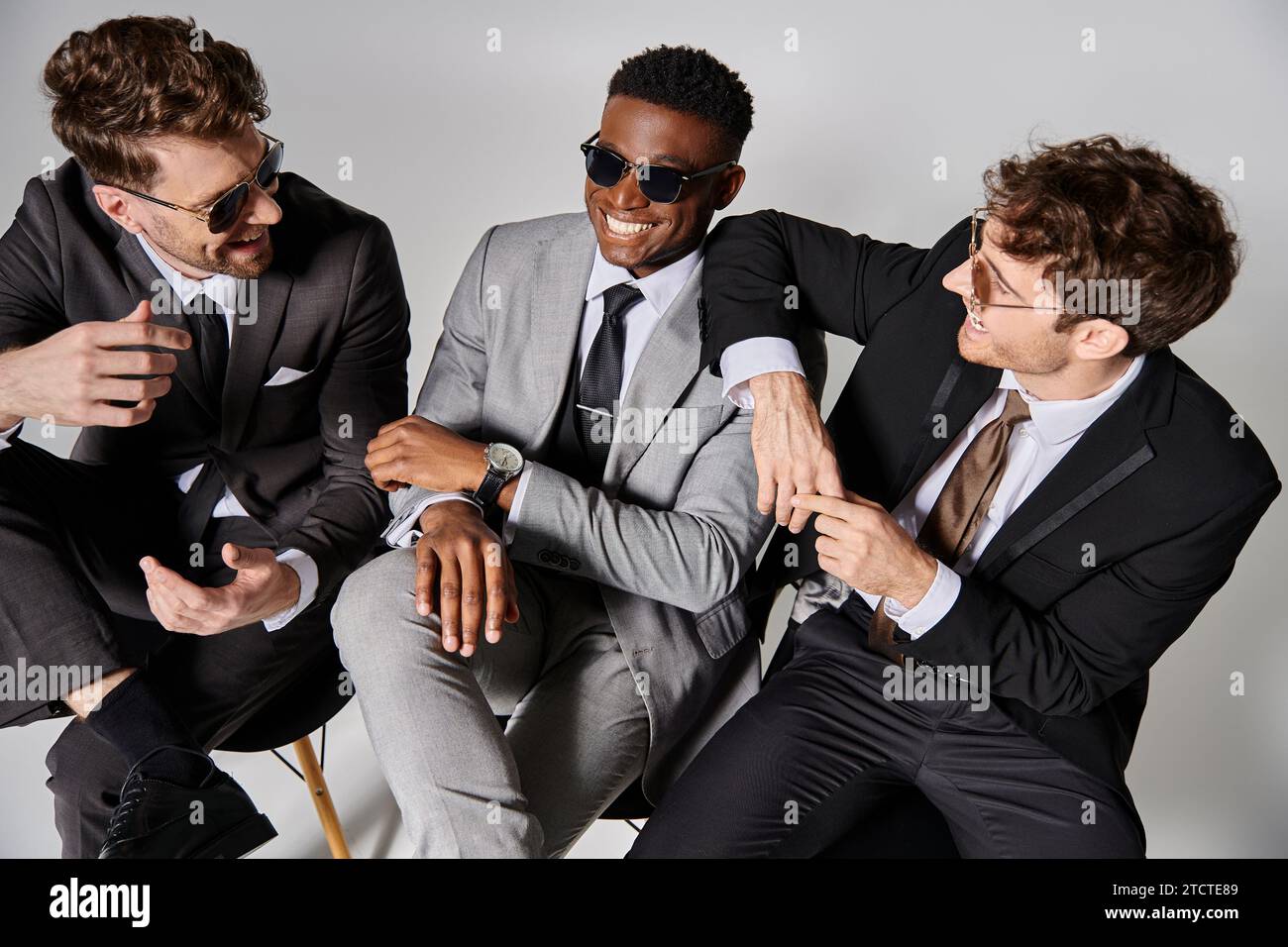 happy attractive multicultural men in business smart suits sitting on ...