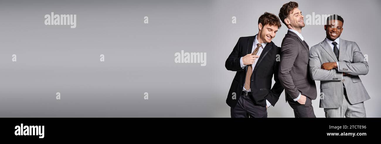 multicultural male models in business casual outfits posing on gray ...