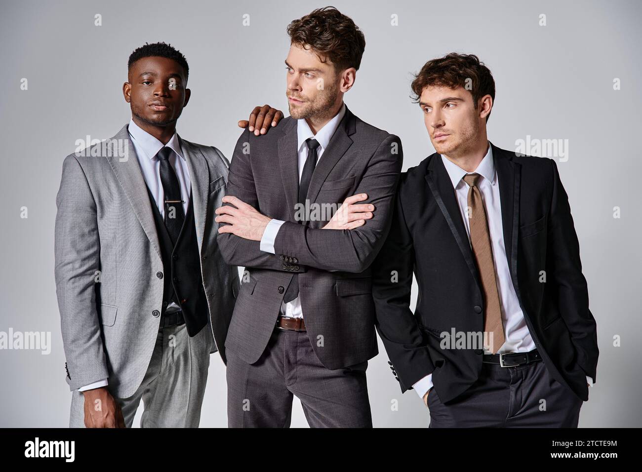 attractive young interracial friends in smart business suits posing ...