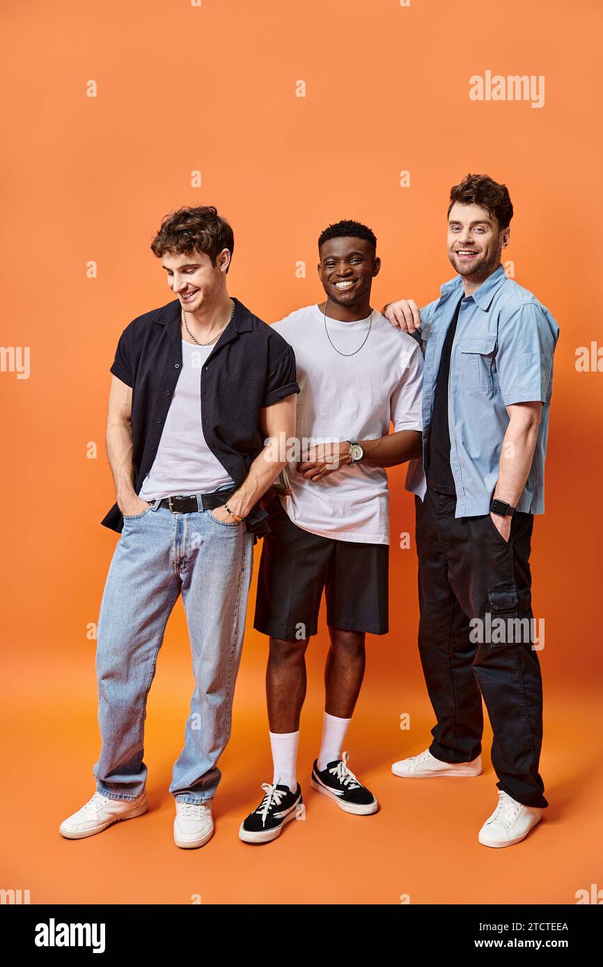 cheerful trendy multicultural men in urban casual outfits smiling ...