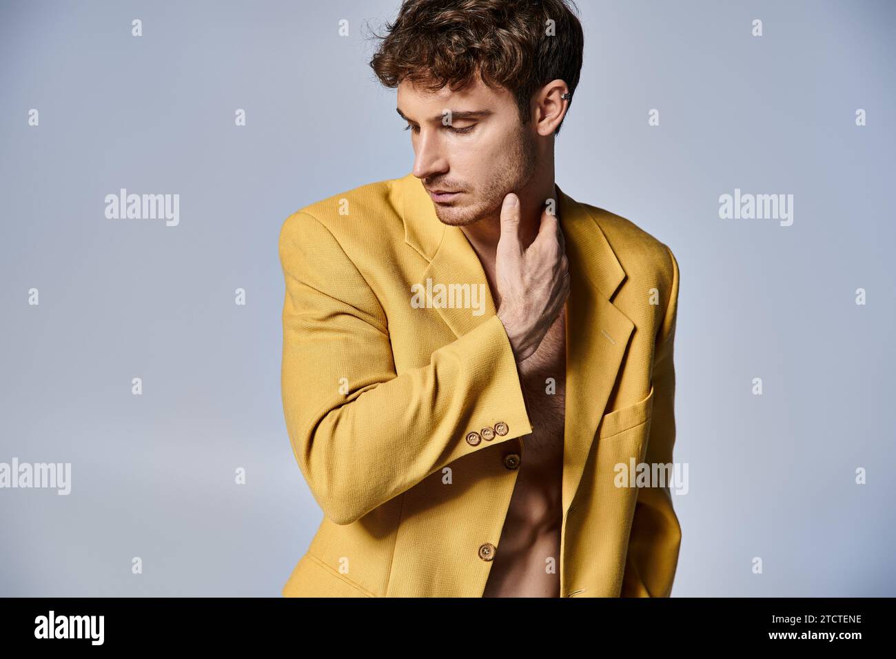 appealing young man in stylish yellow jacket posing attractively on ...