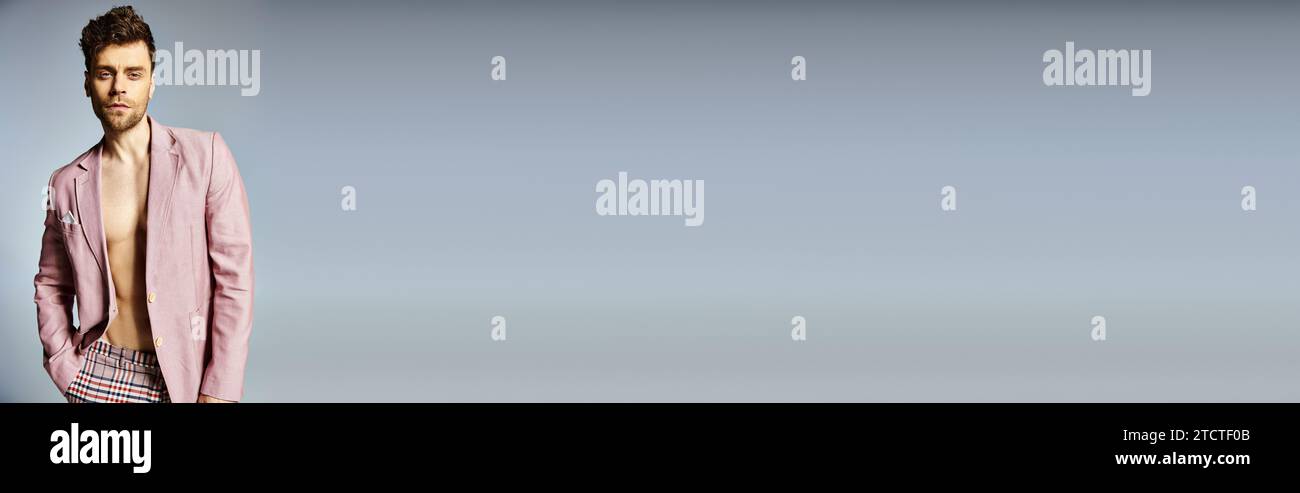 appealing stylish male model in bright pink suit posing on gray ...