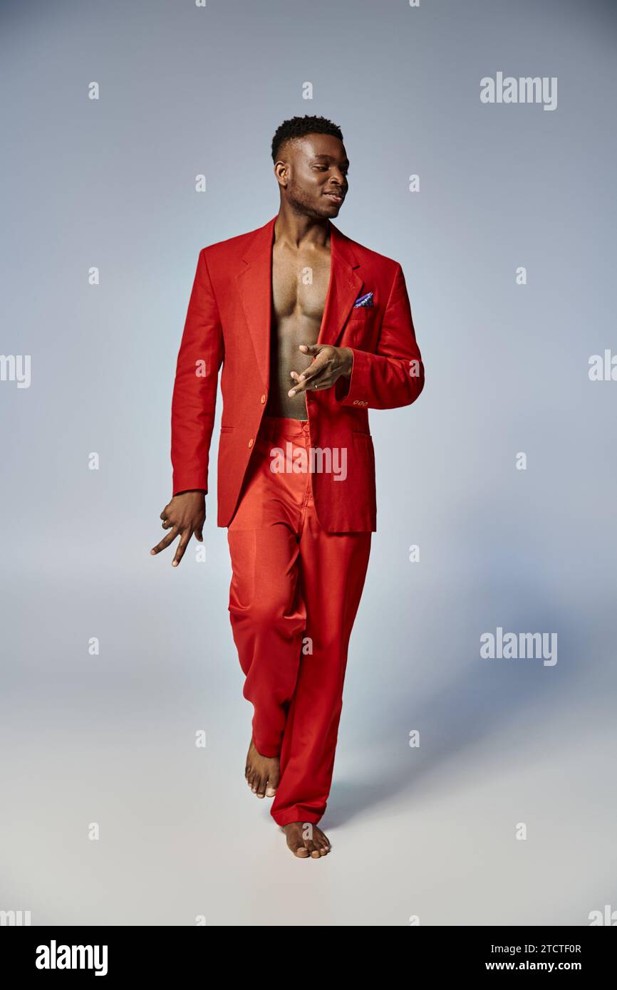 trendy african american male model with dapper style posing on gray backdrop, fashion concept ...