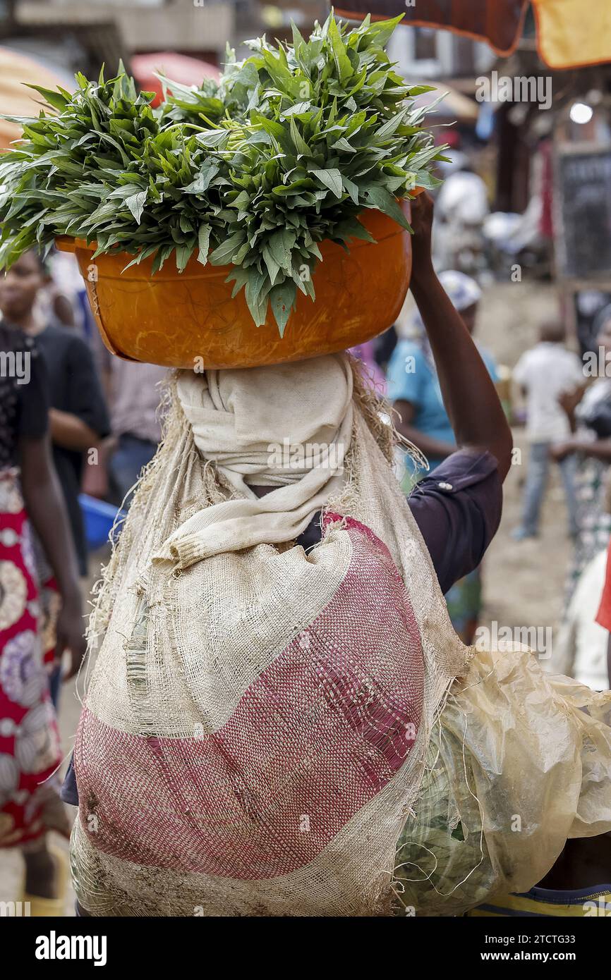 Woman carrying loads on her head and back in Bukavu, DRC Stock Photo ...