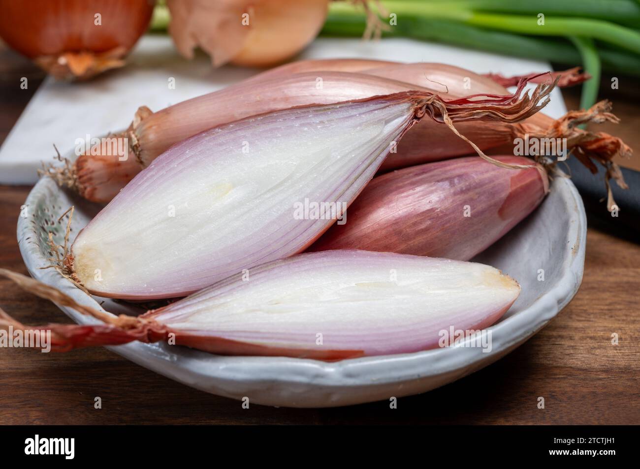 French long pink shallots grappe onion from Brittany, France close up ...