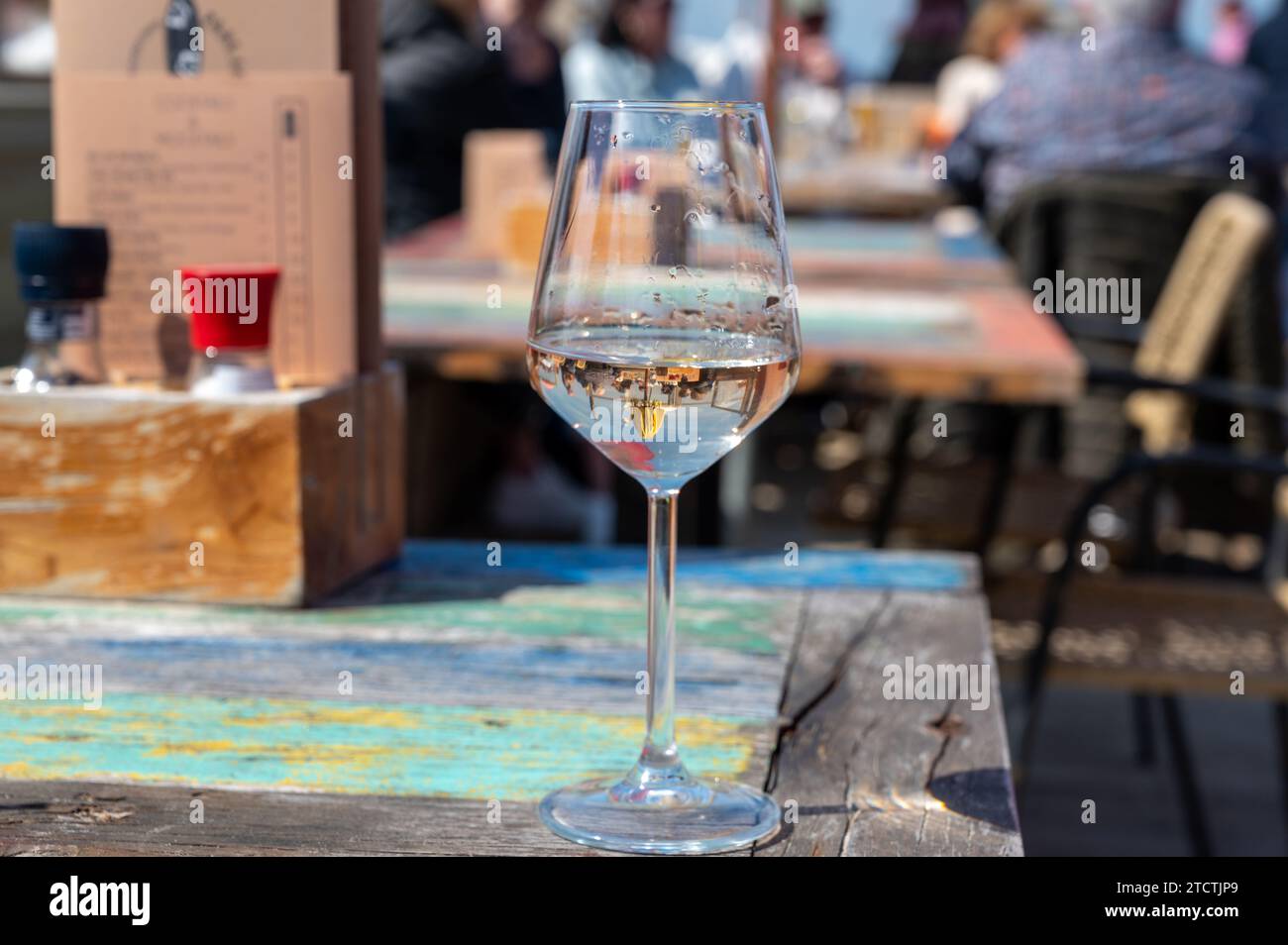 Drinking of pinot grigio dry cold wine, served outdoor in beach cafe in ...
