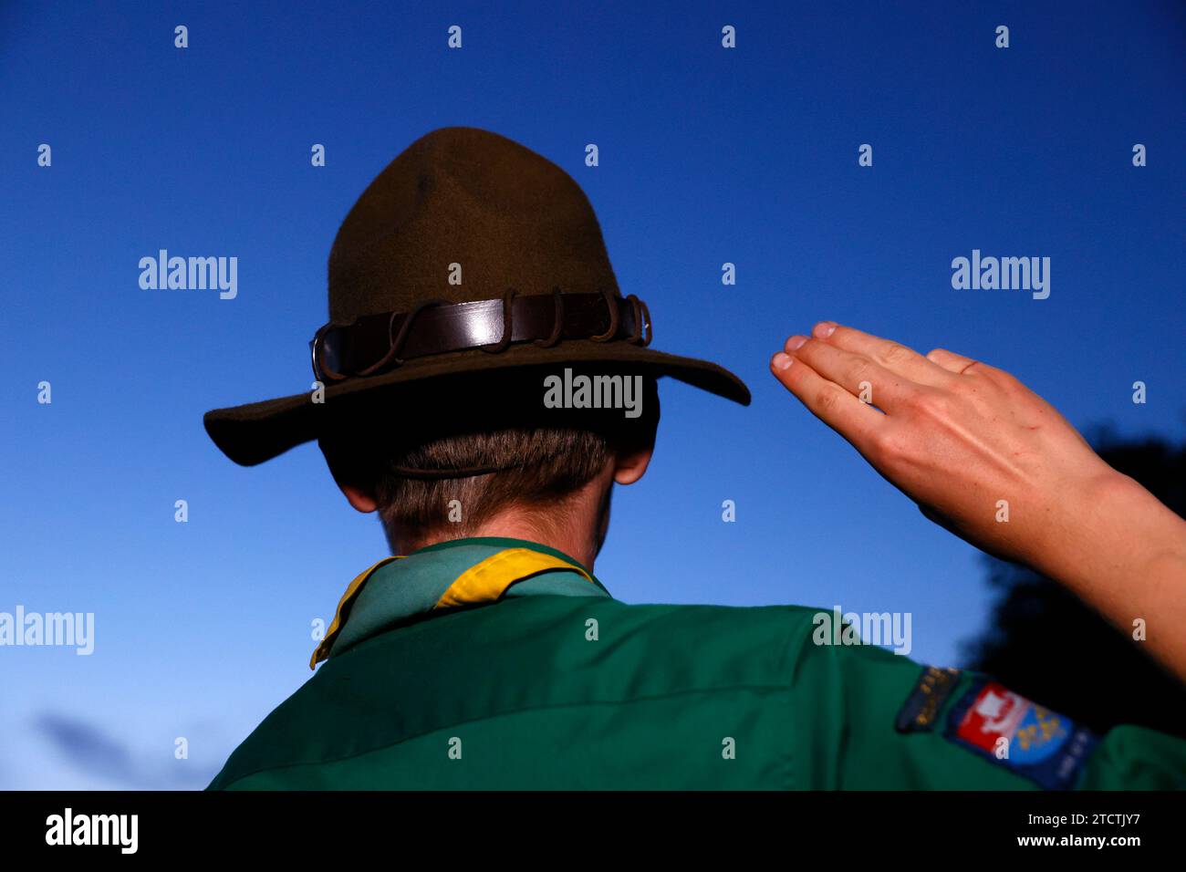 Boy scout in uniform performs three finger salute. Scout symbol hand ...