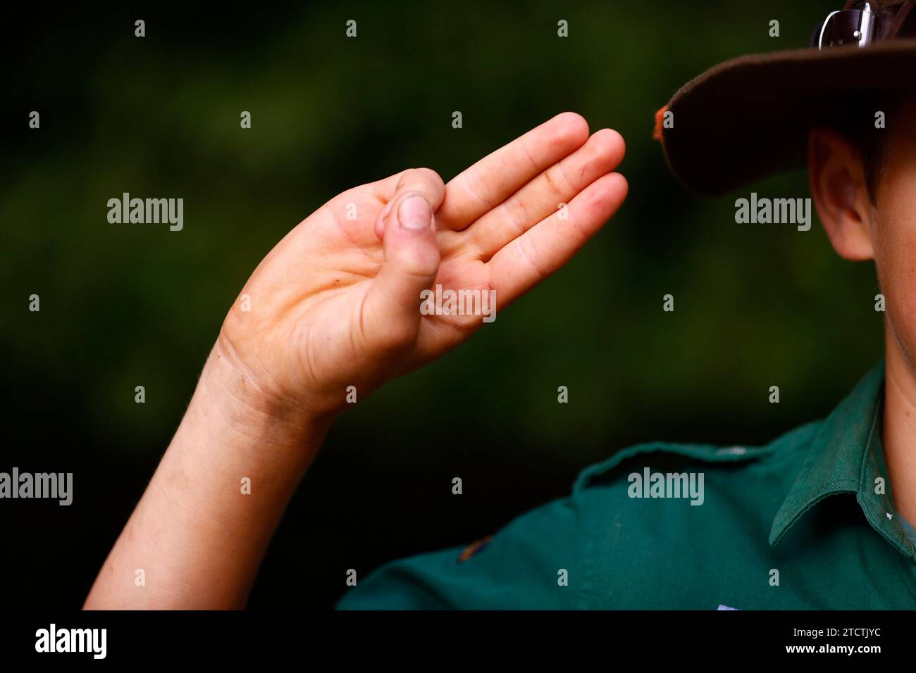 Boy scout in uniform performs three finger salute. Scout symbol hand ...