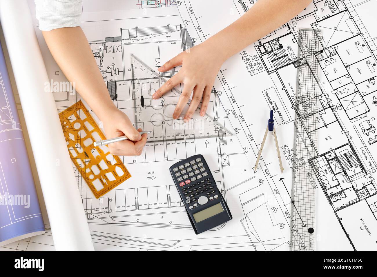 Female engineer designing architectural blueprints at office desk Stock ...