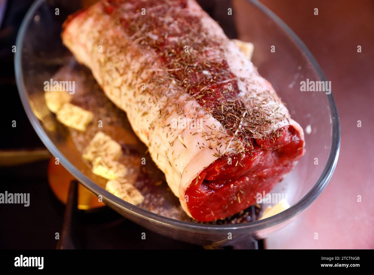 Whole roast beef on a plate ready to cook Stock Photo - Alamy