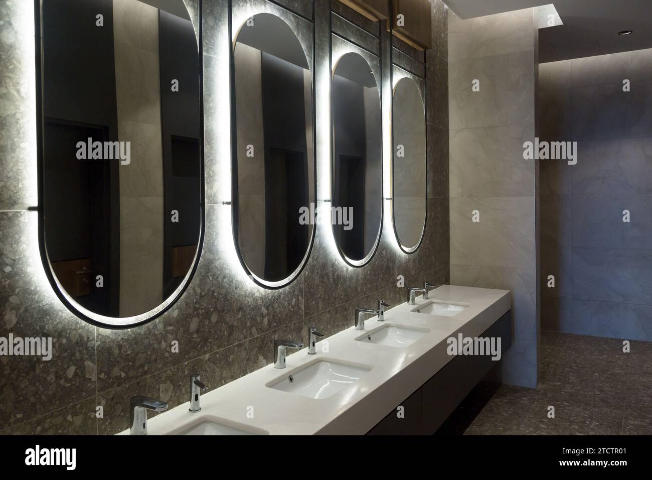 Stylish toilet with cubicles and illuminated mirrors Stock Photo - Alamy