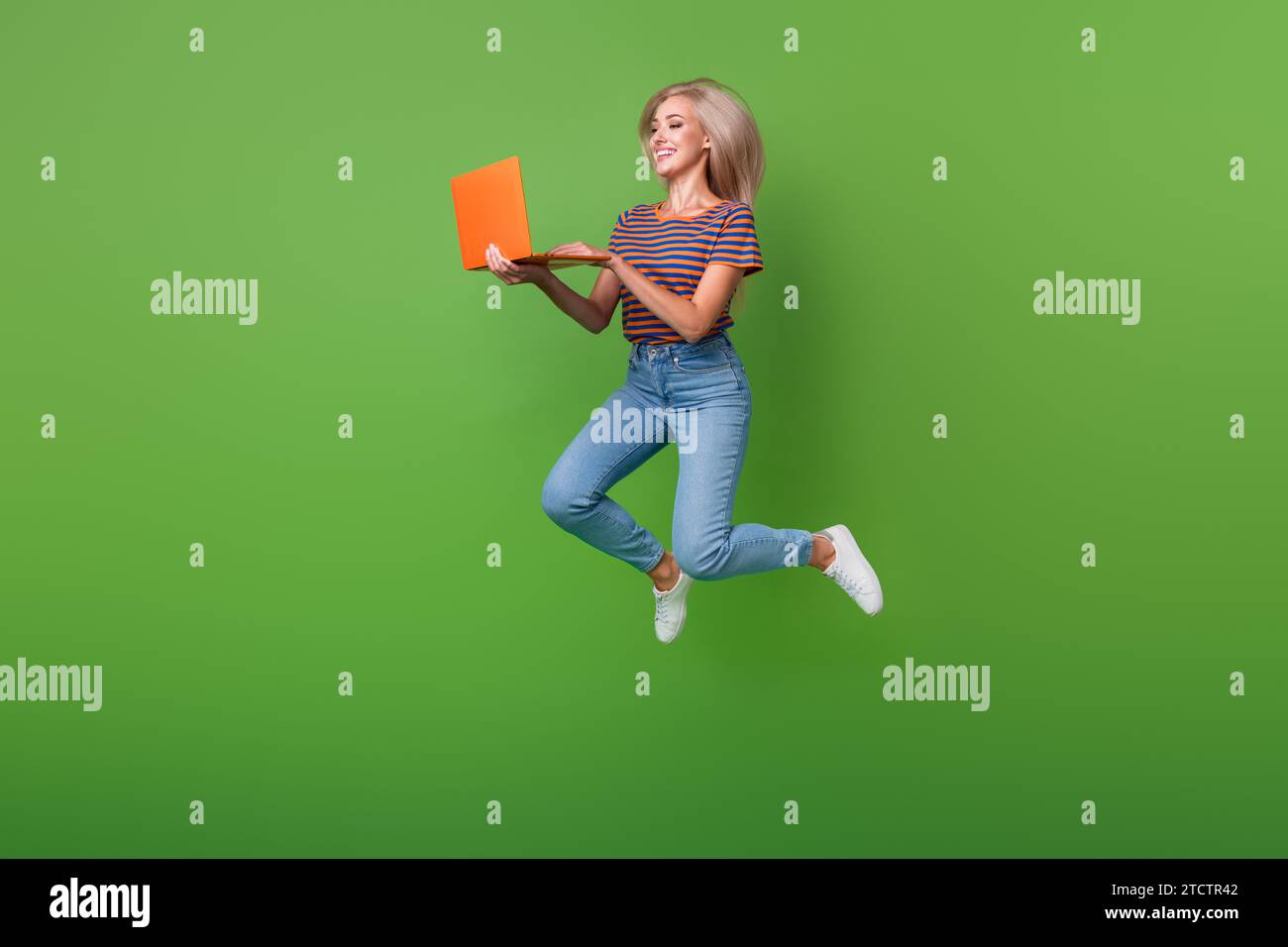 Full body photo jumping air girl browsing laptop computer having fun ...