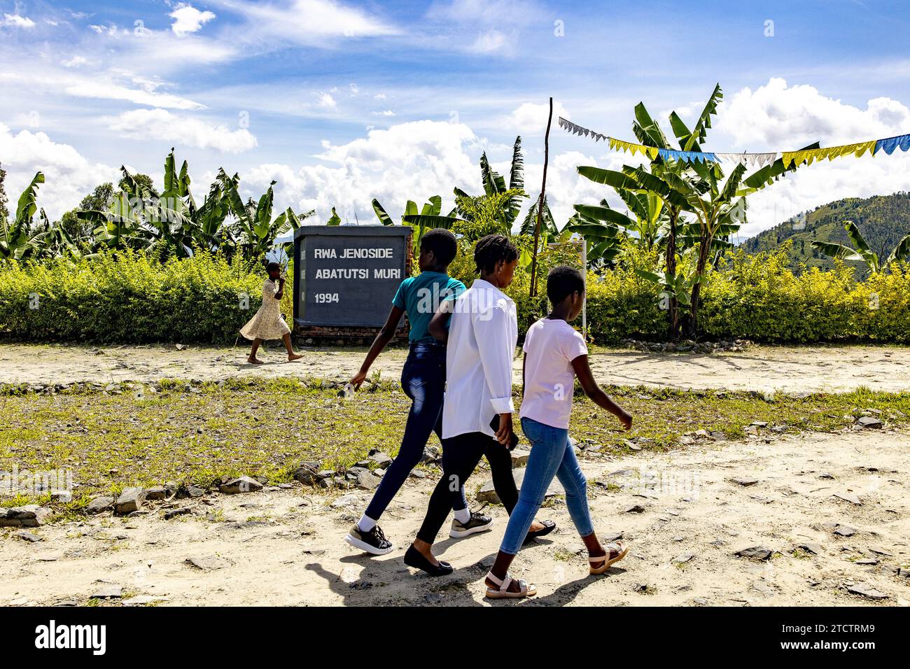 Parishioners walking past a genocide memorial sign on their way to ...
