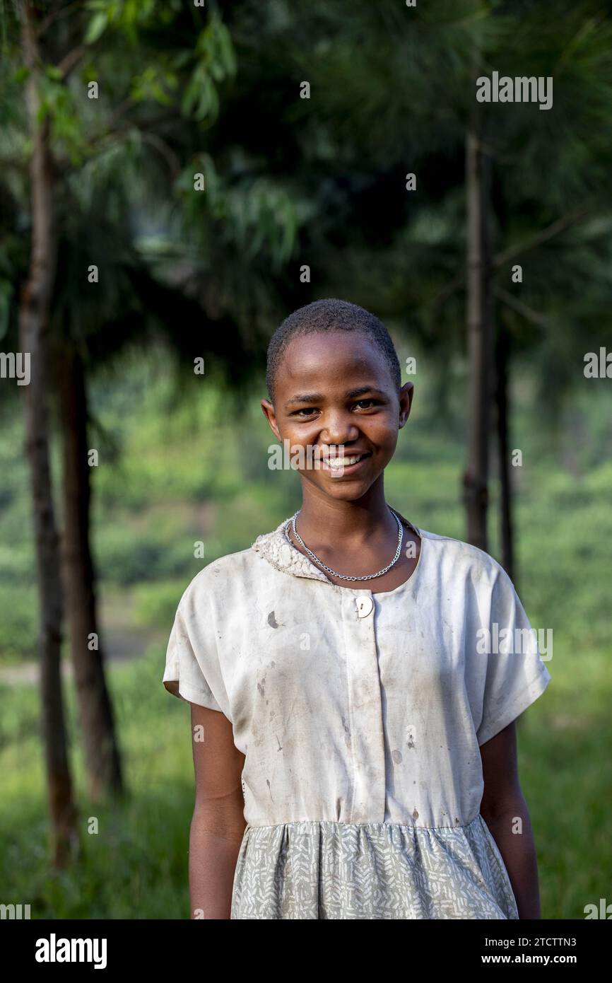 Smiling Rwandan girl standing in front of trees near Karongi, Rwanda ...