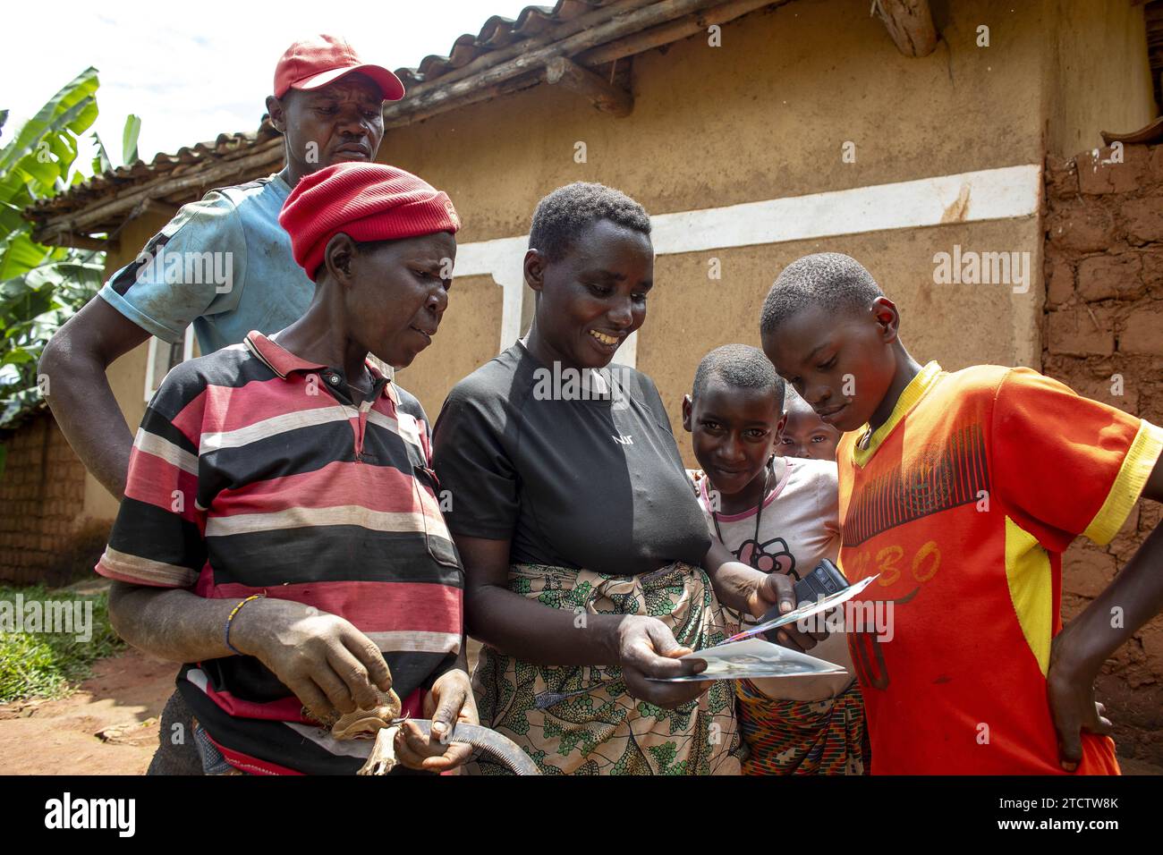 Family looking at printed photographs in a southern province village ...