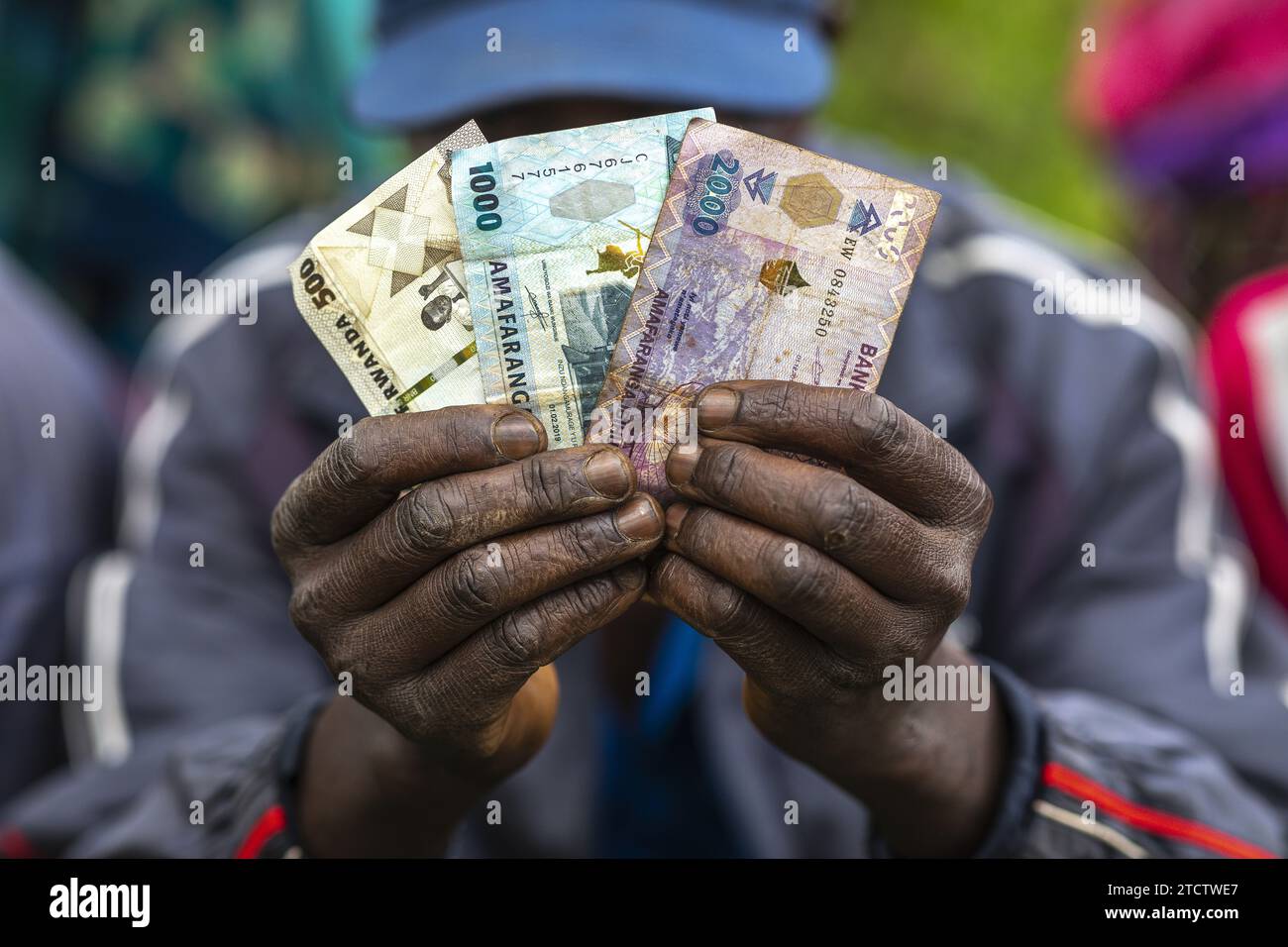 Microfinance borrower holding bank notes in a village near Huye ...