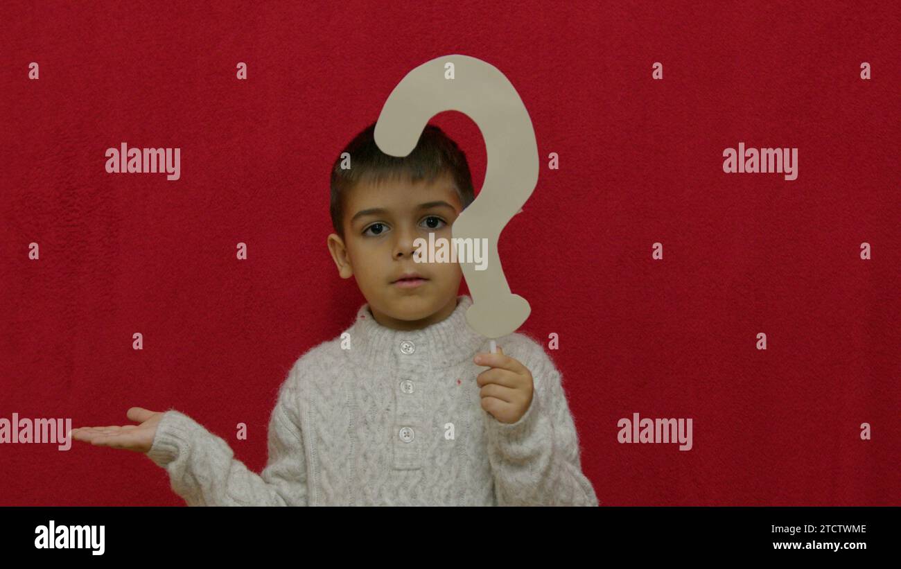 Cute child questioning something. Holding question mark , isolated on ...