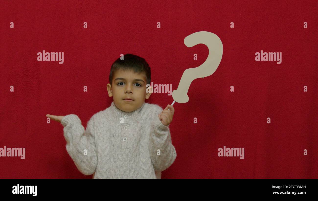 Cute child questioning something. Holding question mark , isolated on ...