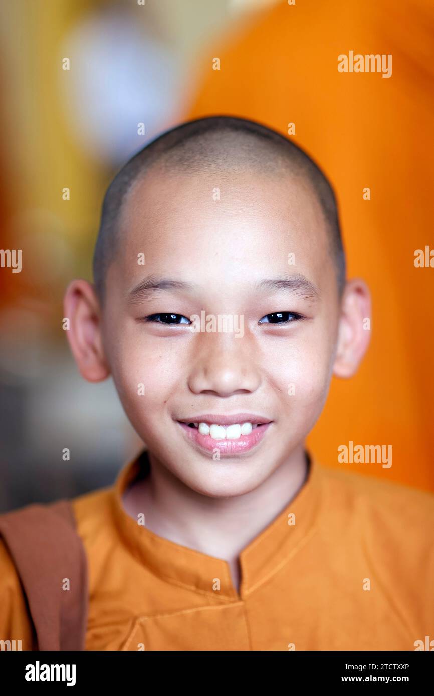 Phuoc Hue buddhist pagoda. Portrait of a novice monk in orange robe ...