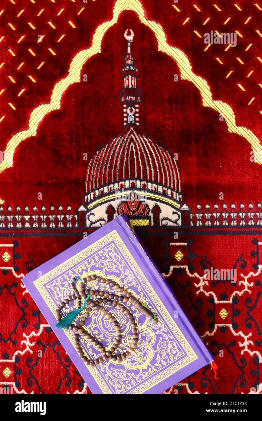 Quran and muslim prayer beads on islamic prayer mat. Symbol of Islam ...