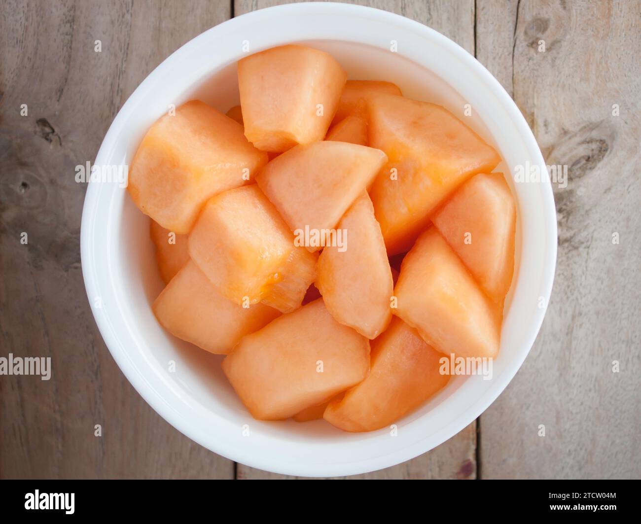 closeup melon slice in white dish with wood table background Stock ...