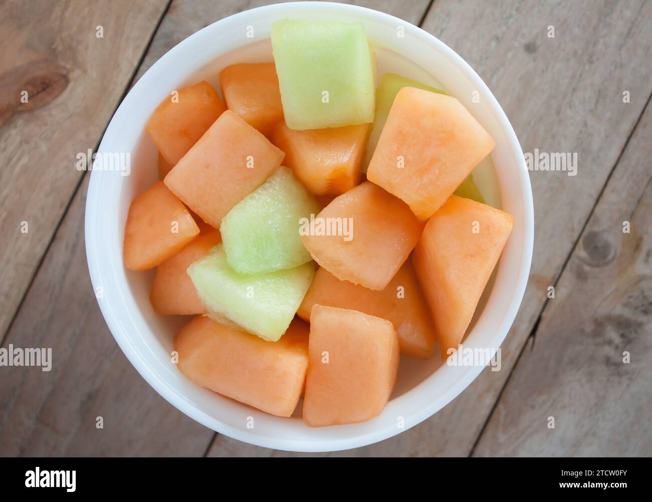 closeup melon slice in white dish with wood table background Stock ...