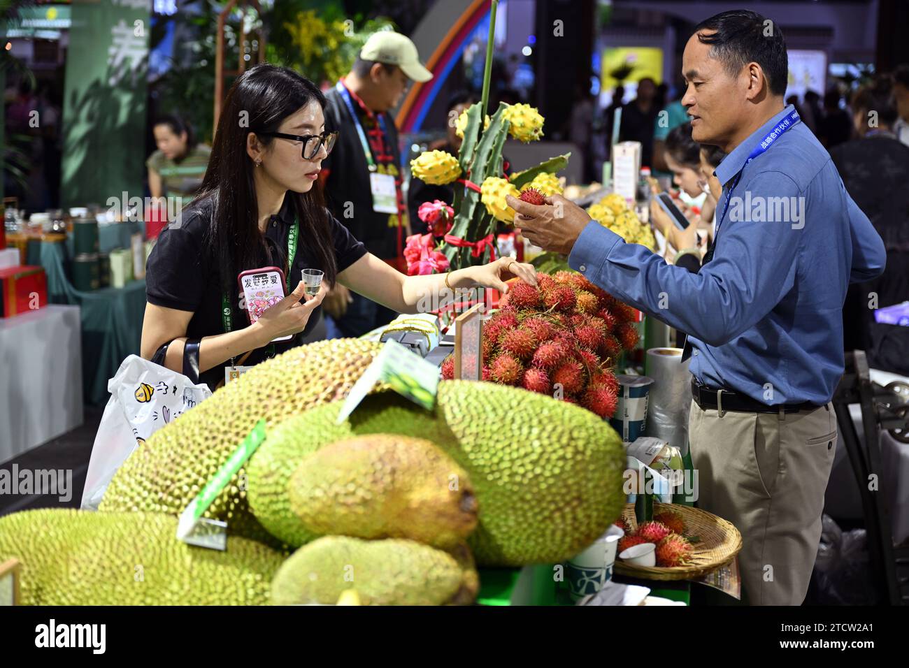 (231214) -- HAIKOU, Dec. 14, 2023 (Xinhua) -- Visitors select tropical ...