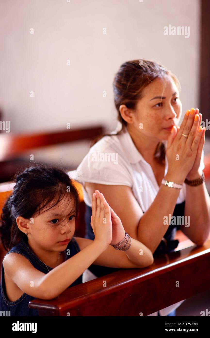 Dalat Cathedral. Mother and daughter praying together in church. Can ...