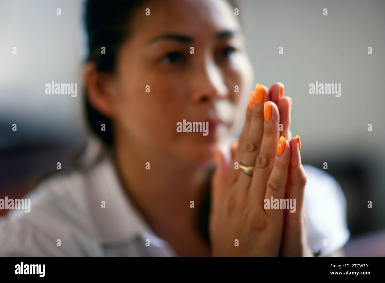 Catholic woman praying alone in a church. Can Tho. Vietnam Stock Photo ...