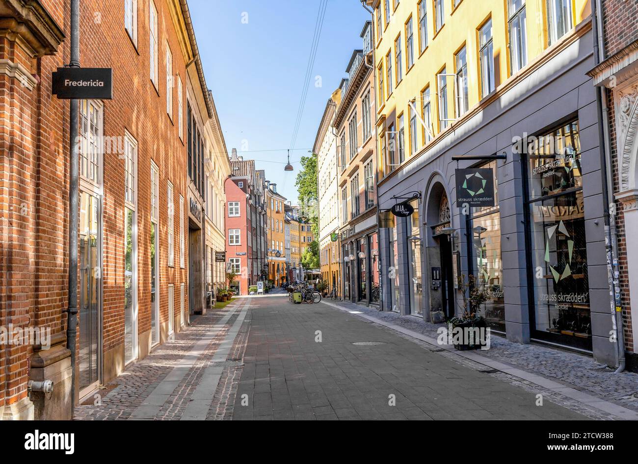 Downtown Copenhagen with old houses and store signs on a sunny day ...