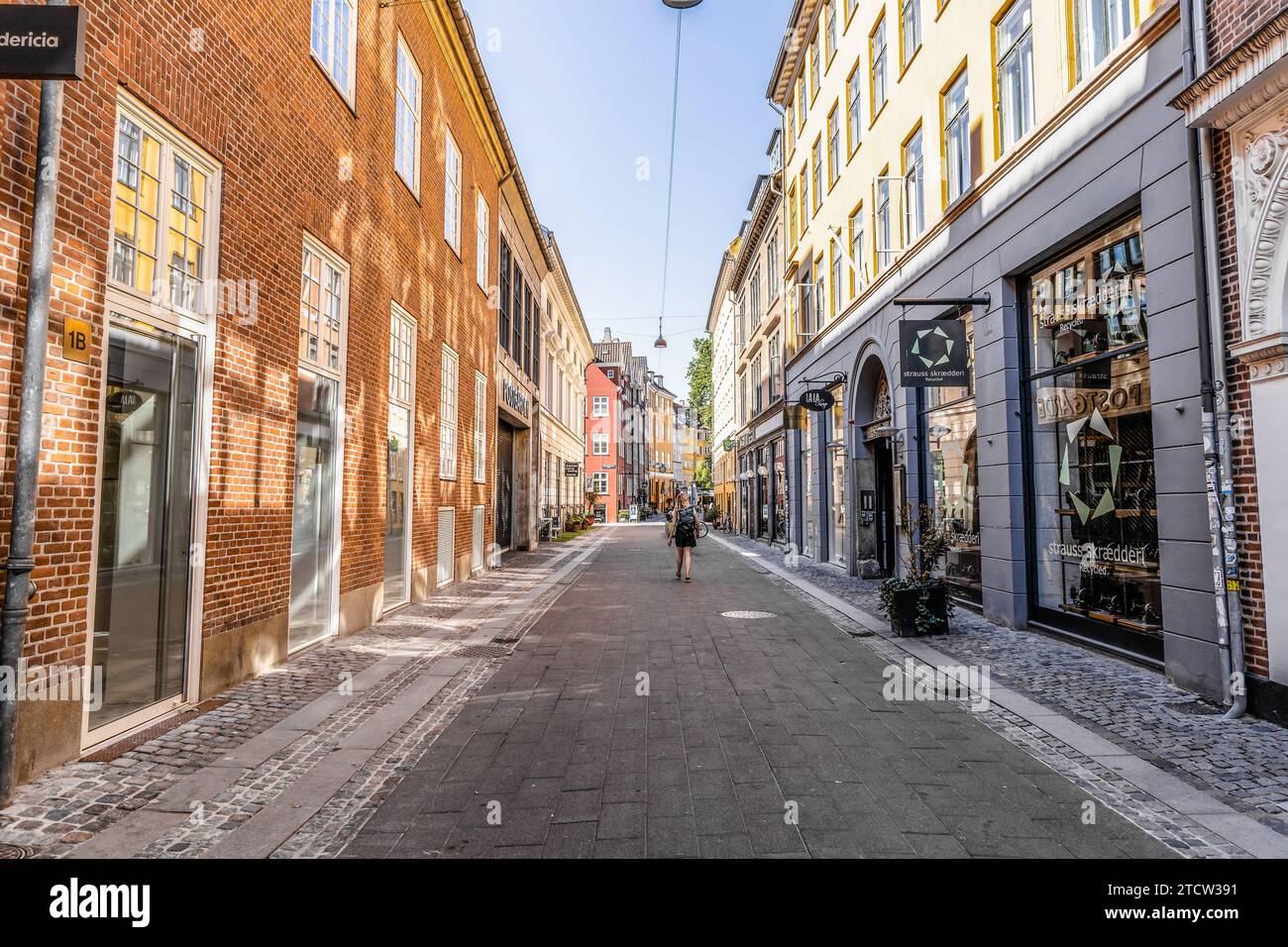 A female tourist with a backpack walks along the street of a big city ...