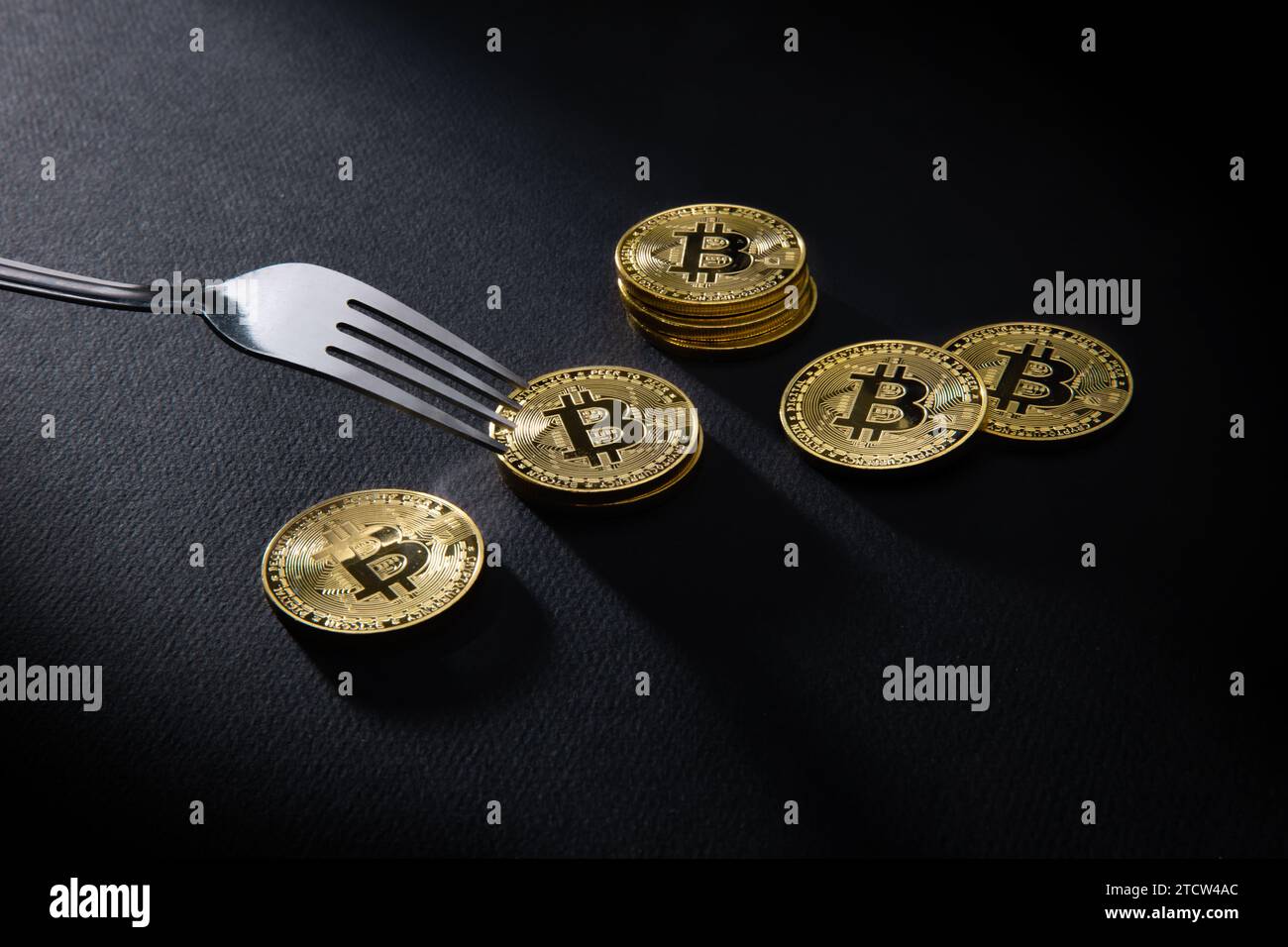 Bitcoin hard fork image in strong shadow on black paper Stock Photo - Alamy