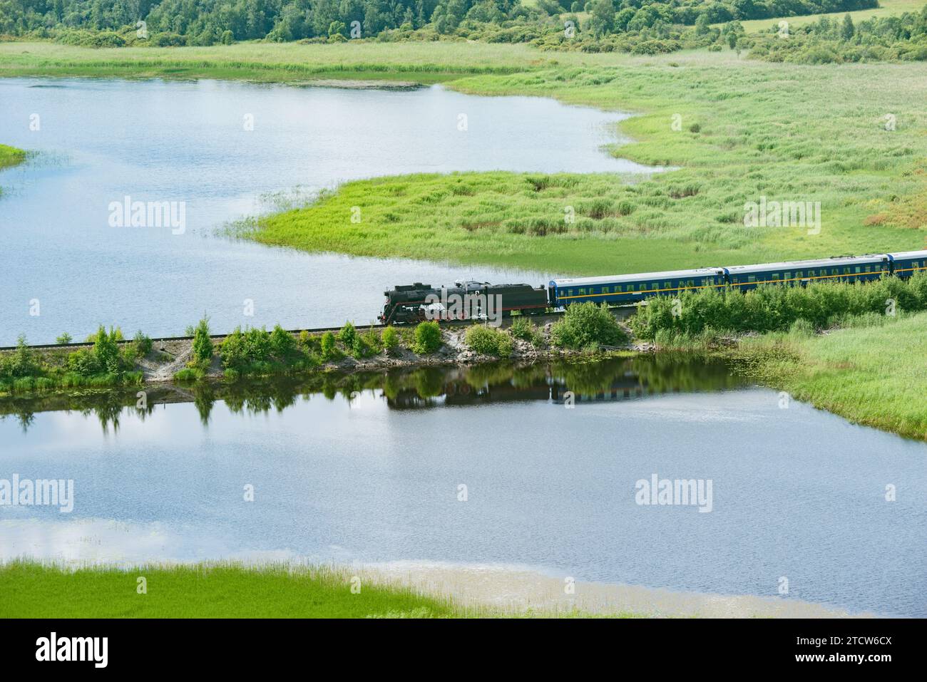Retro steam train moves along the lake Stock Photo - Alamy