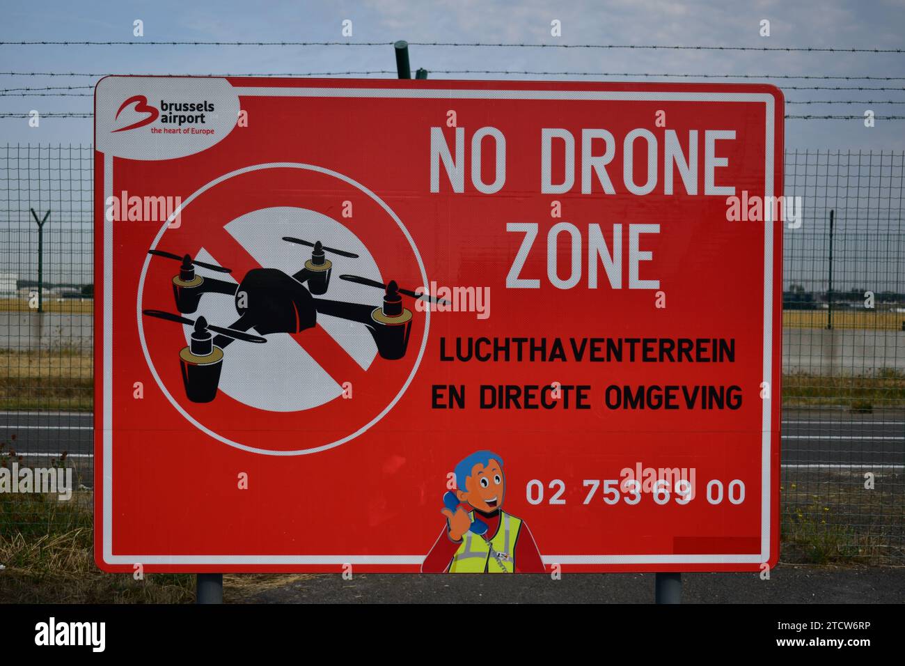 Rectangular red warning sign "NO DRONE ZONE" near the fence that ...